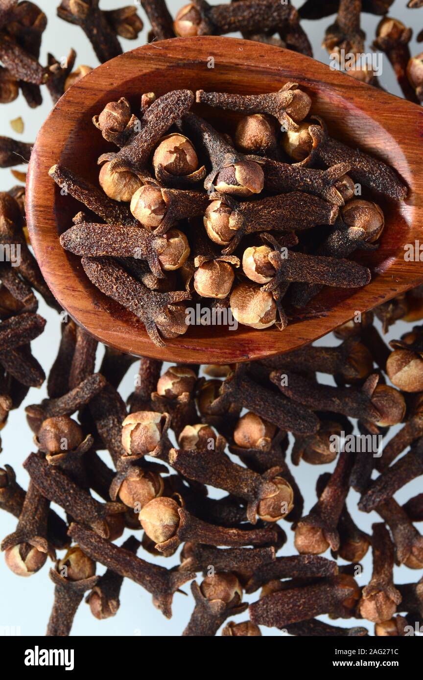 Cloves (spice) and wooden spoon close-up food background. Isolated on ...