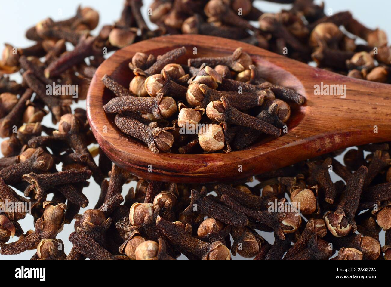 Cloves (spice) and wooden spoon close-up food background. Isolated on ...