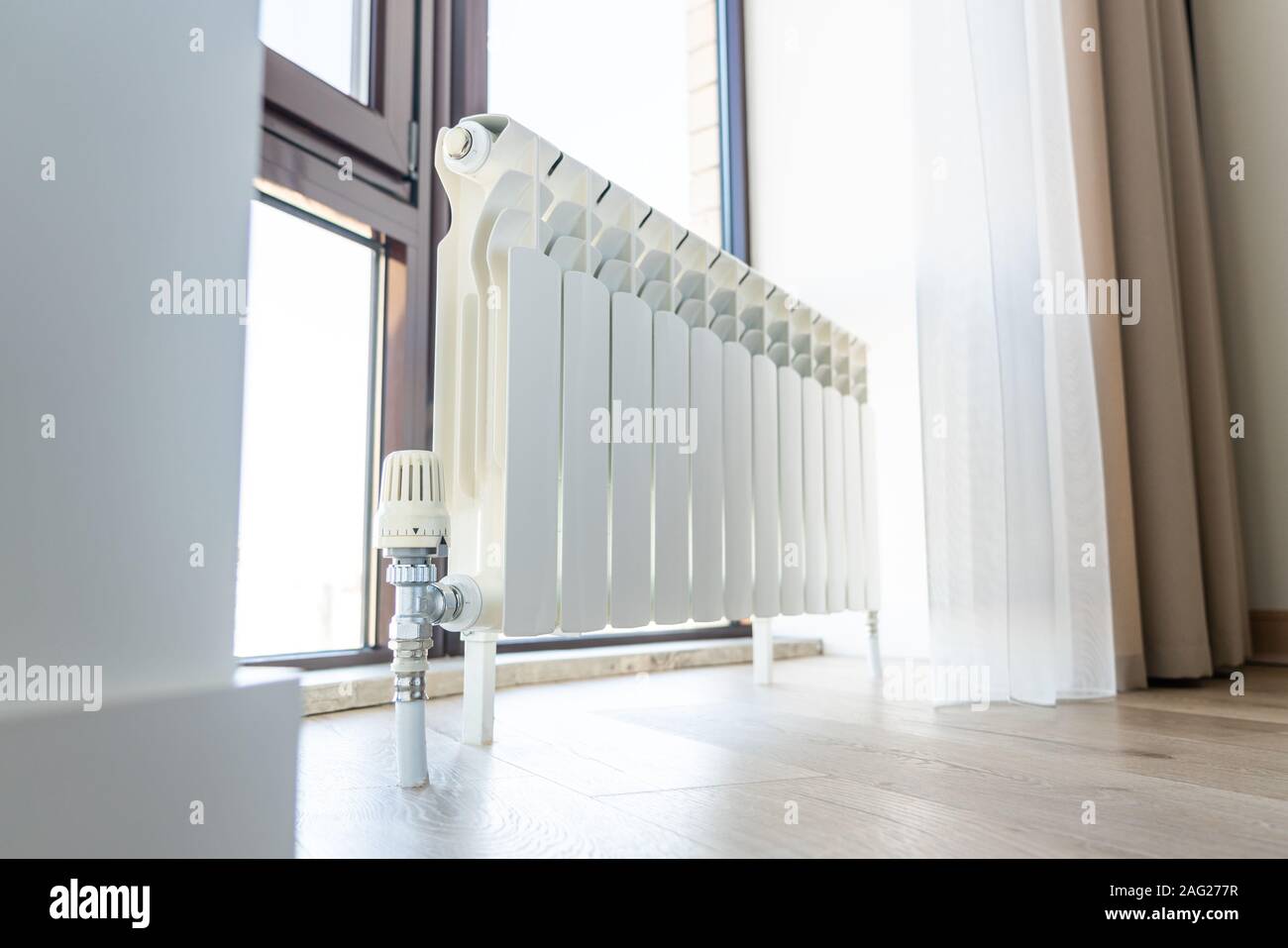 White big radiator near window in a modern room Stock Photo - Alamy