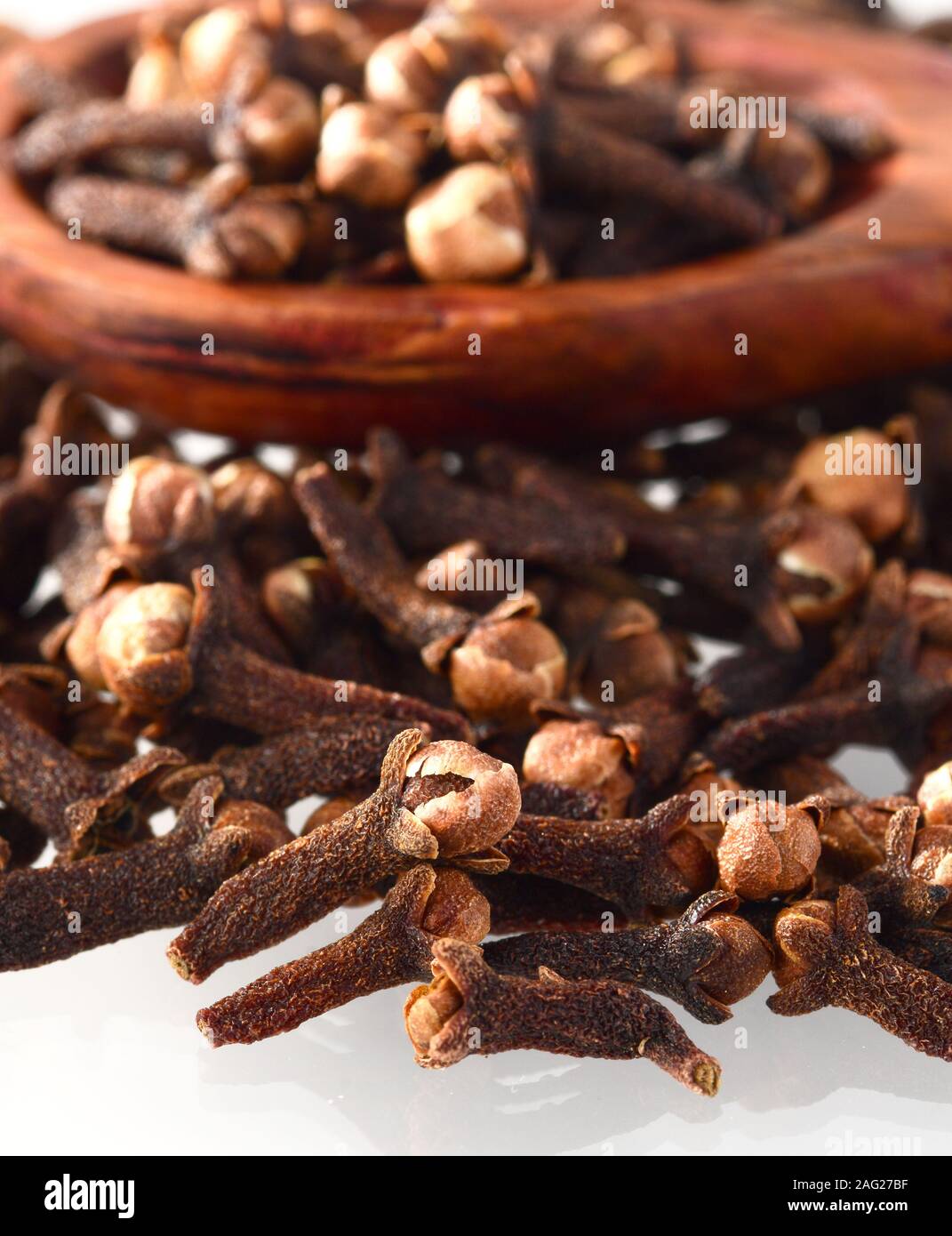Cloves (spice) and wooden spoon close-up food background. Isolated on ...