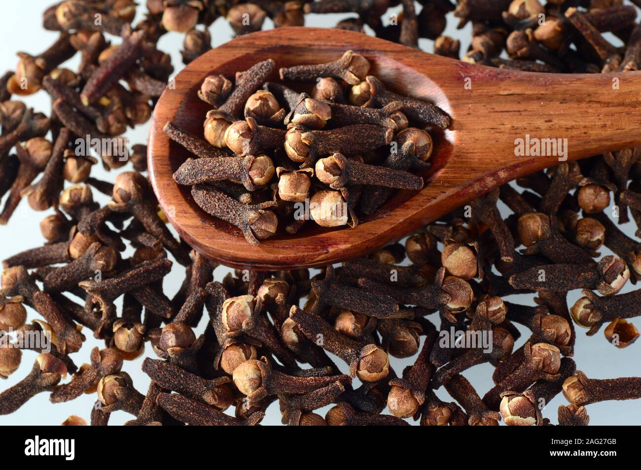 Cloves (spice) and wooden spoon close-up food background. Isolated on ...