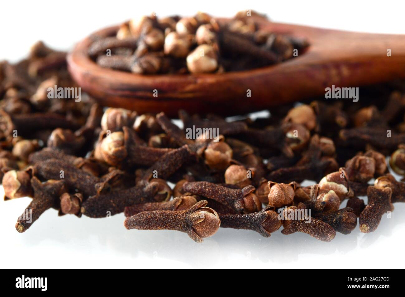 Cloves (spice) and wooden spoon close-up food background. Isolated on ...
