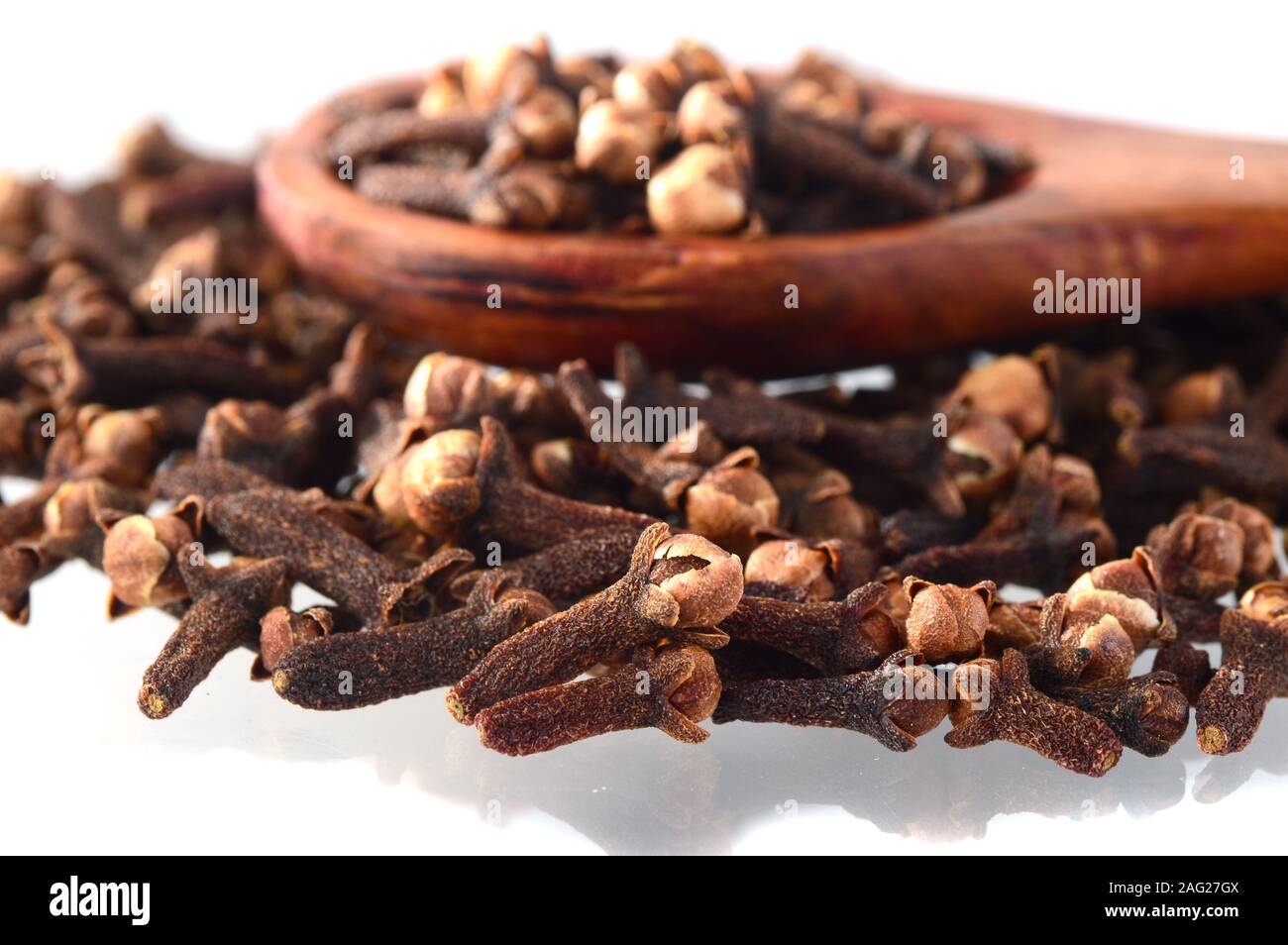 Cloves (spice) and wooden spoon close-up food background. Isolated on ...