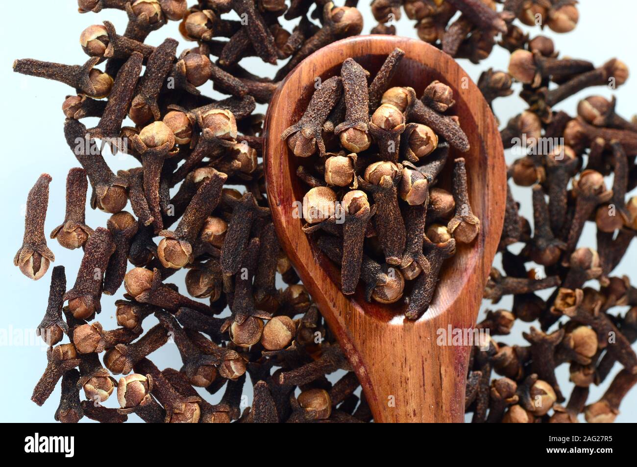 Cloves (spice) and wooden spoon close-up food background. Isolated on ...