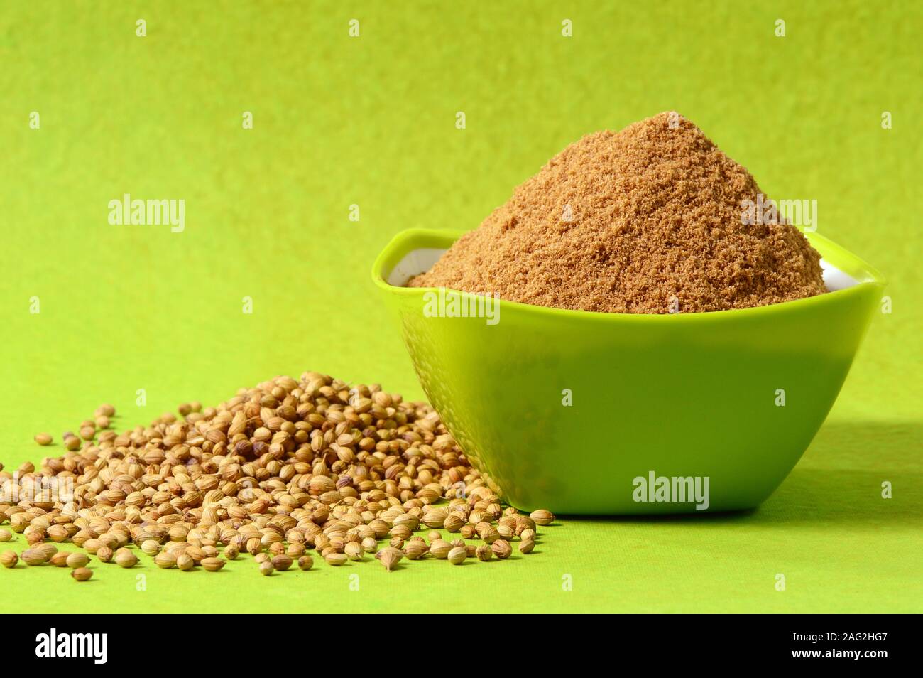 Coriander seeds and Powdered coriander in green container on green ...