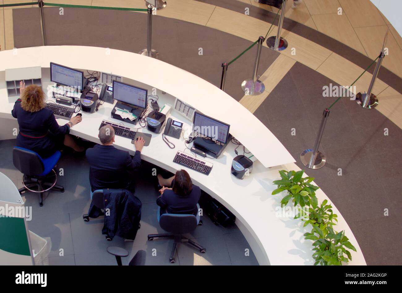 Three customer service agents working at a help desk at the airport ...