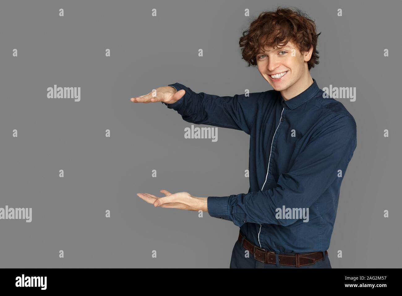 Freestyle. Teenager boy standing isolated on grey showing space for ...