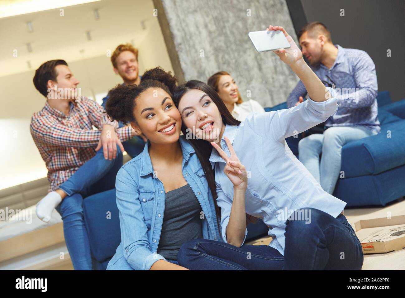 Group of friends having party indoors fun together two girls taking ...