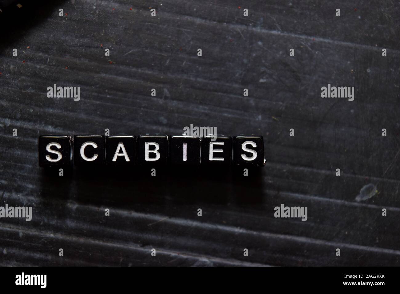 Scabies on wooden cubes. On table background Stock Photo - Alamy