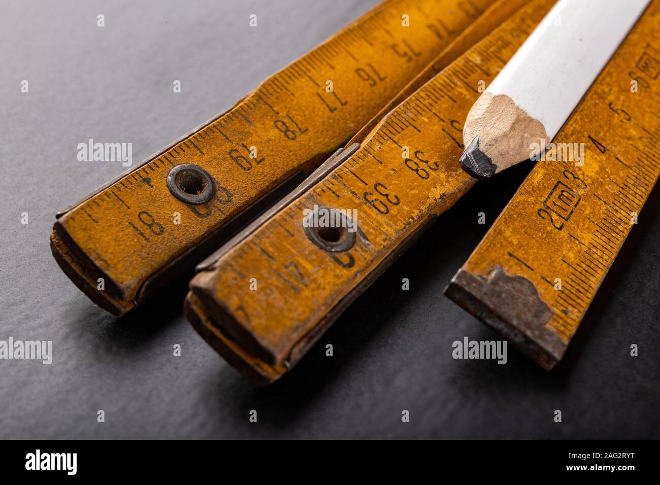 Carpentry measure and white pencil on a dark table. Tools needed to ...
