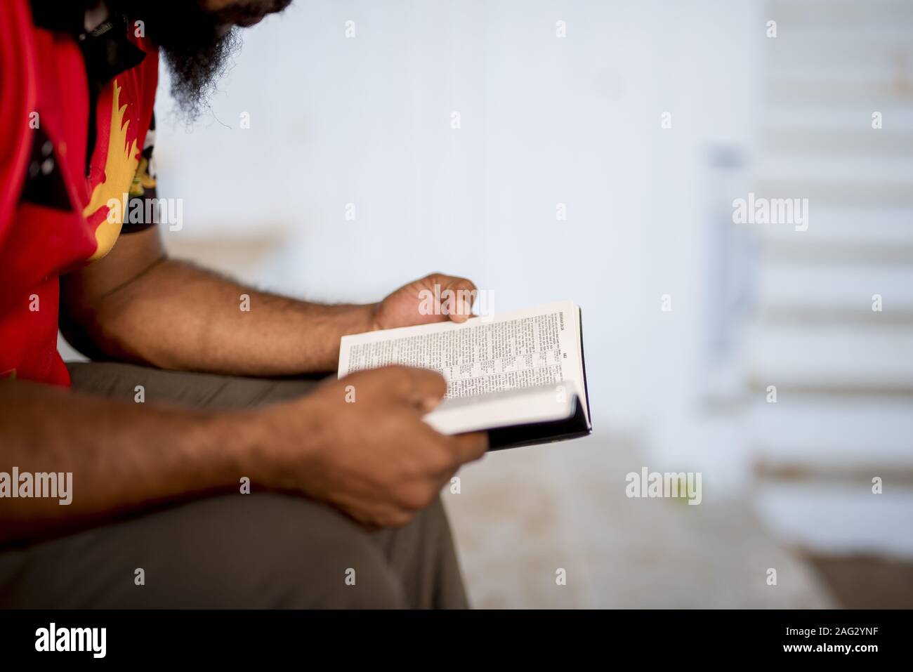 Male sitting and reading the bible with a blurred background Stock ...