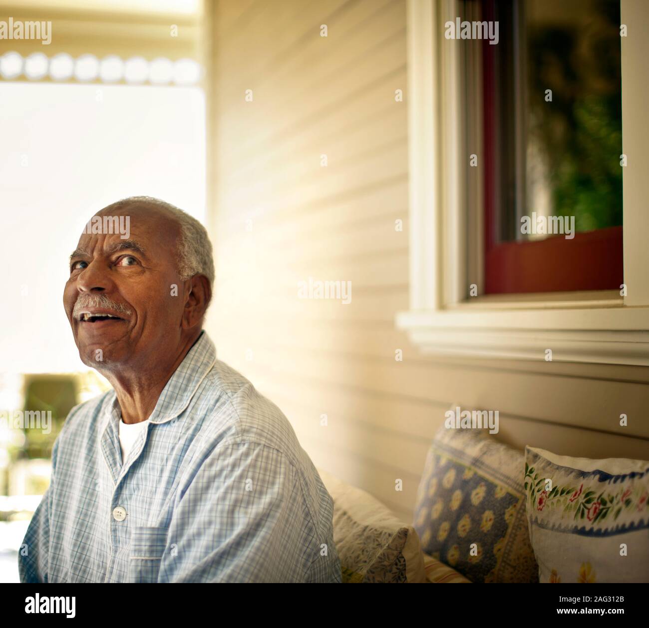 Smiling senior man sitting on the deck of rest-home Stock Photo - Alamy