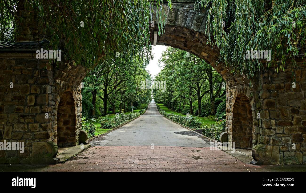 Pathway with a gate in the middle of green leafed trees Stock Photo - Alamy
