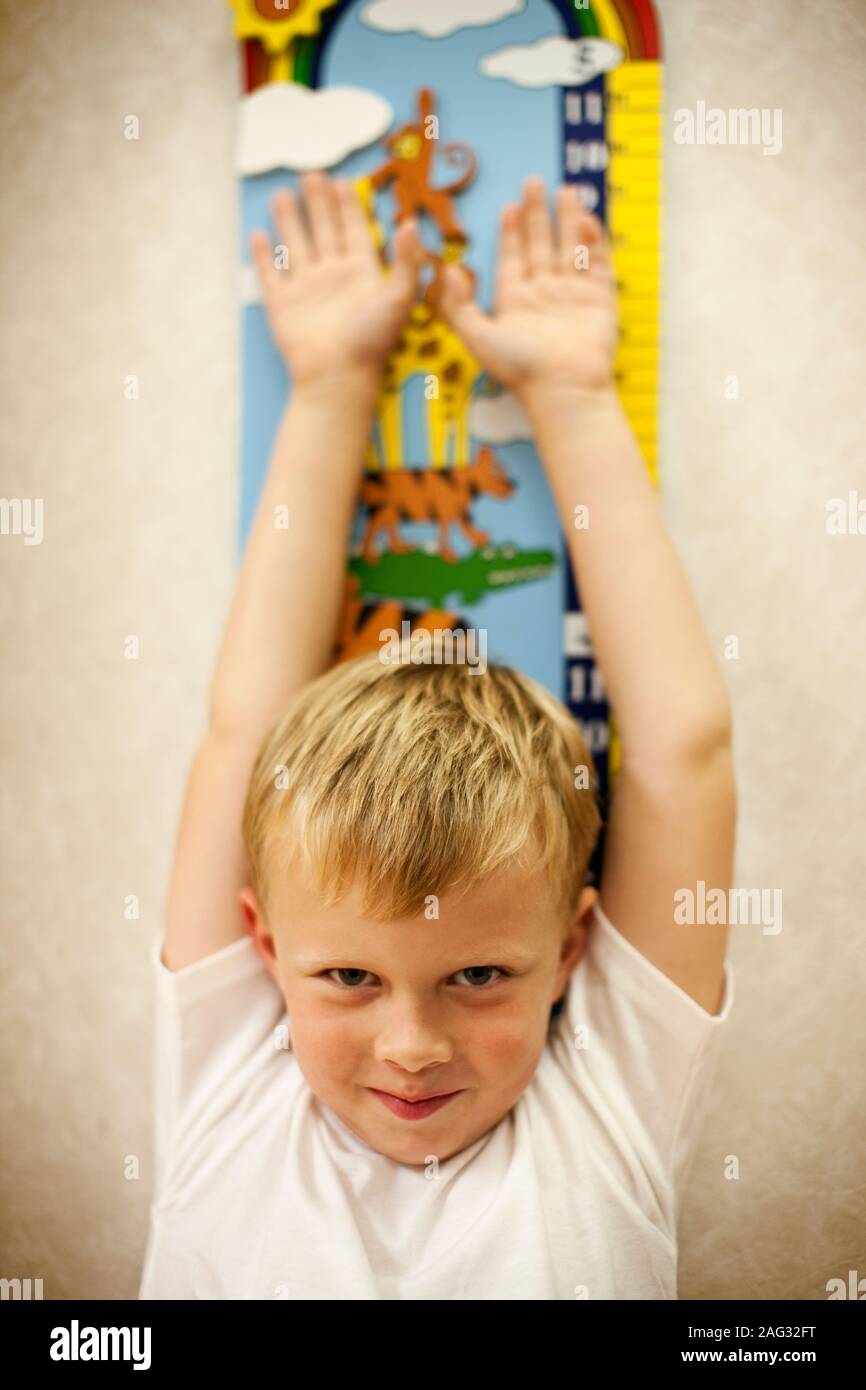 Portrait of the little boy measuring his height Stock Photo - Alamy