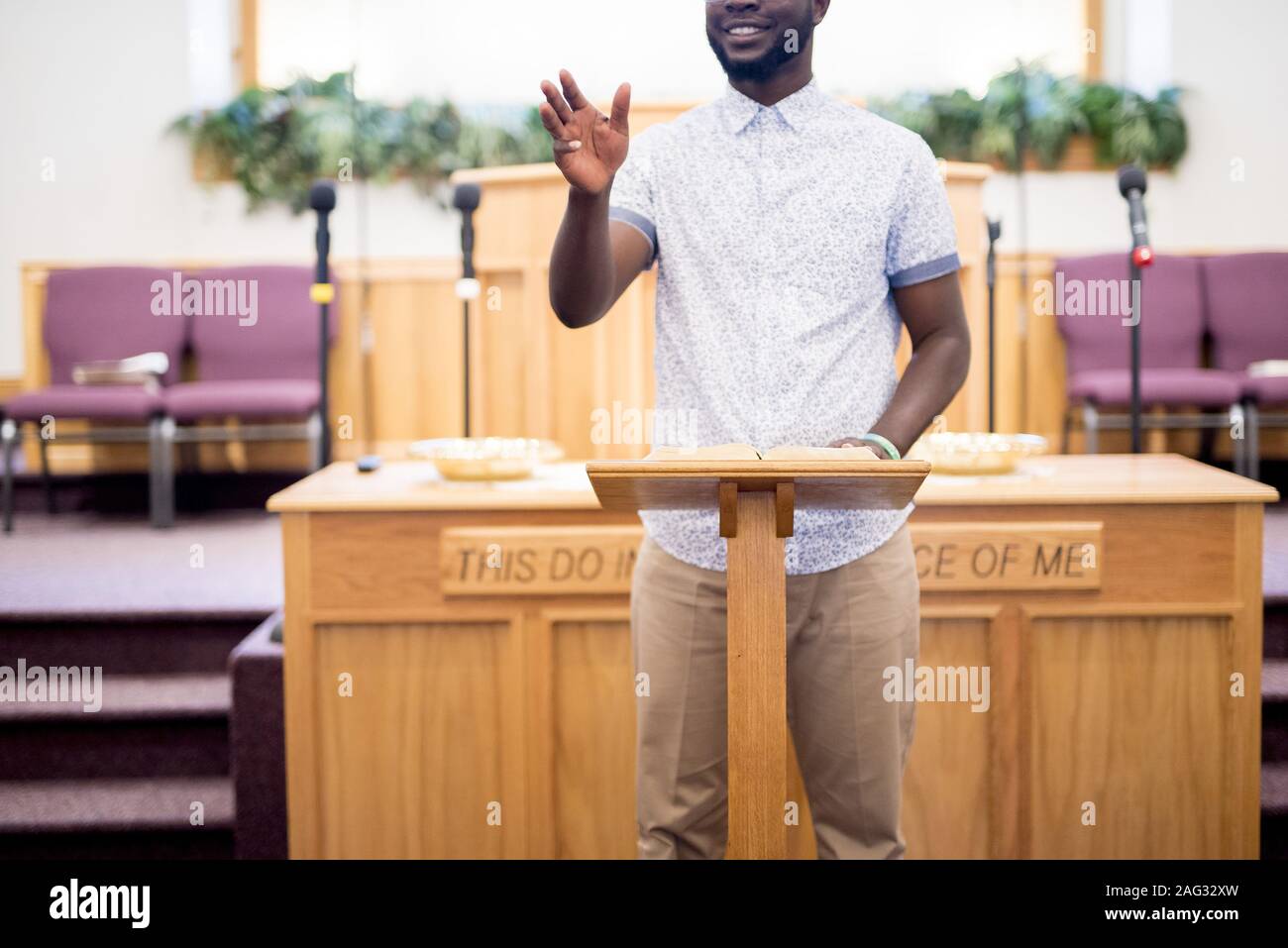 Male standing and reading the bible on a wooden stand in a church Stock ...