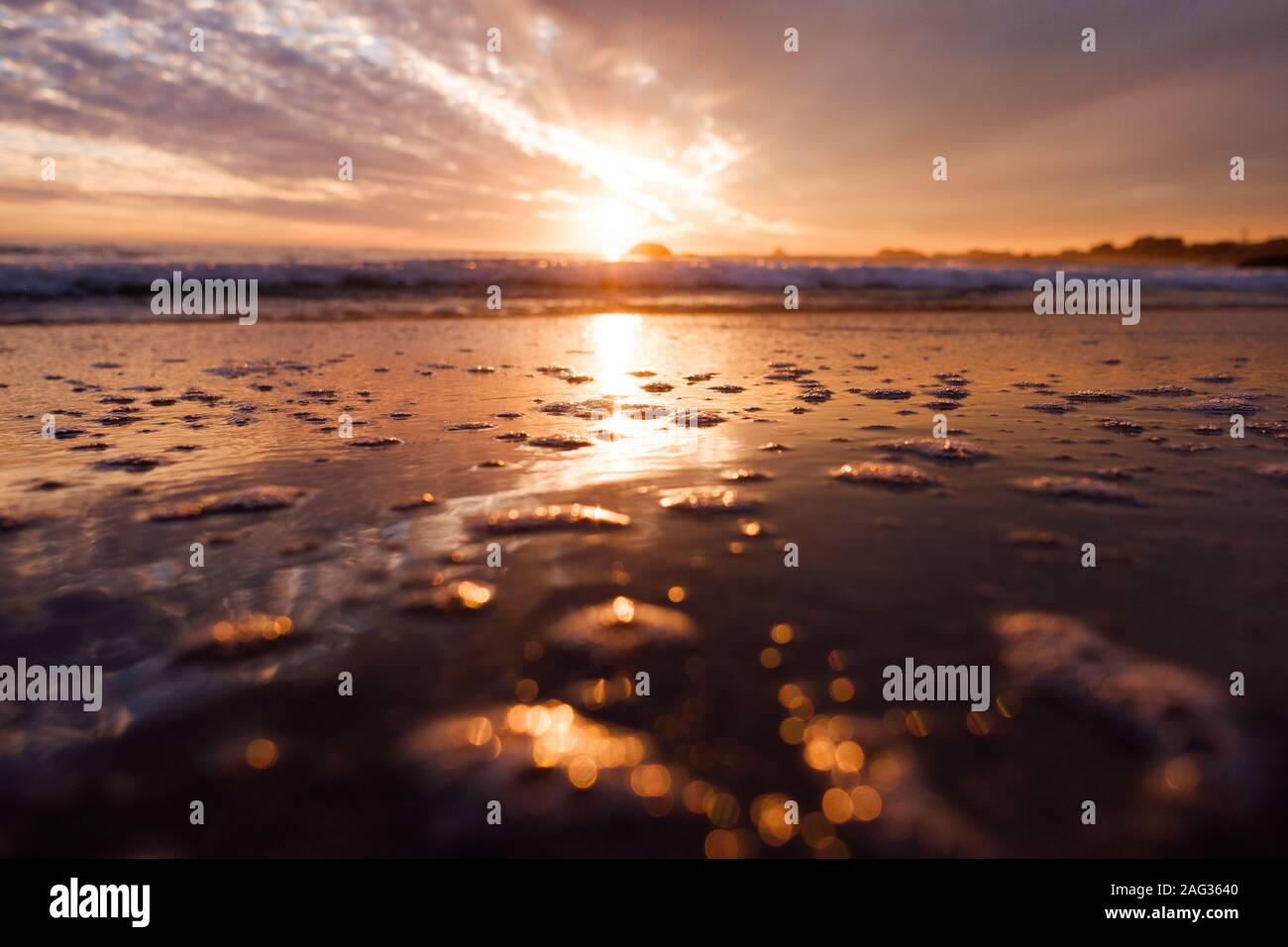 Beautiful scenery of breathtaking sunset reflected in wet sand near the ...