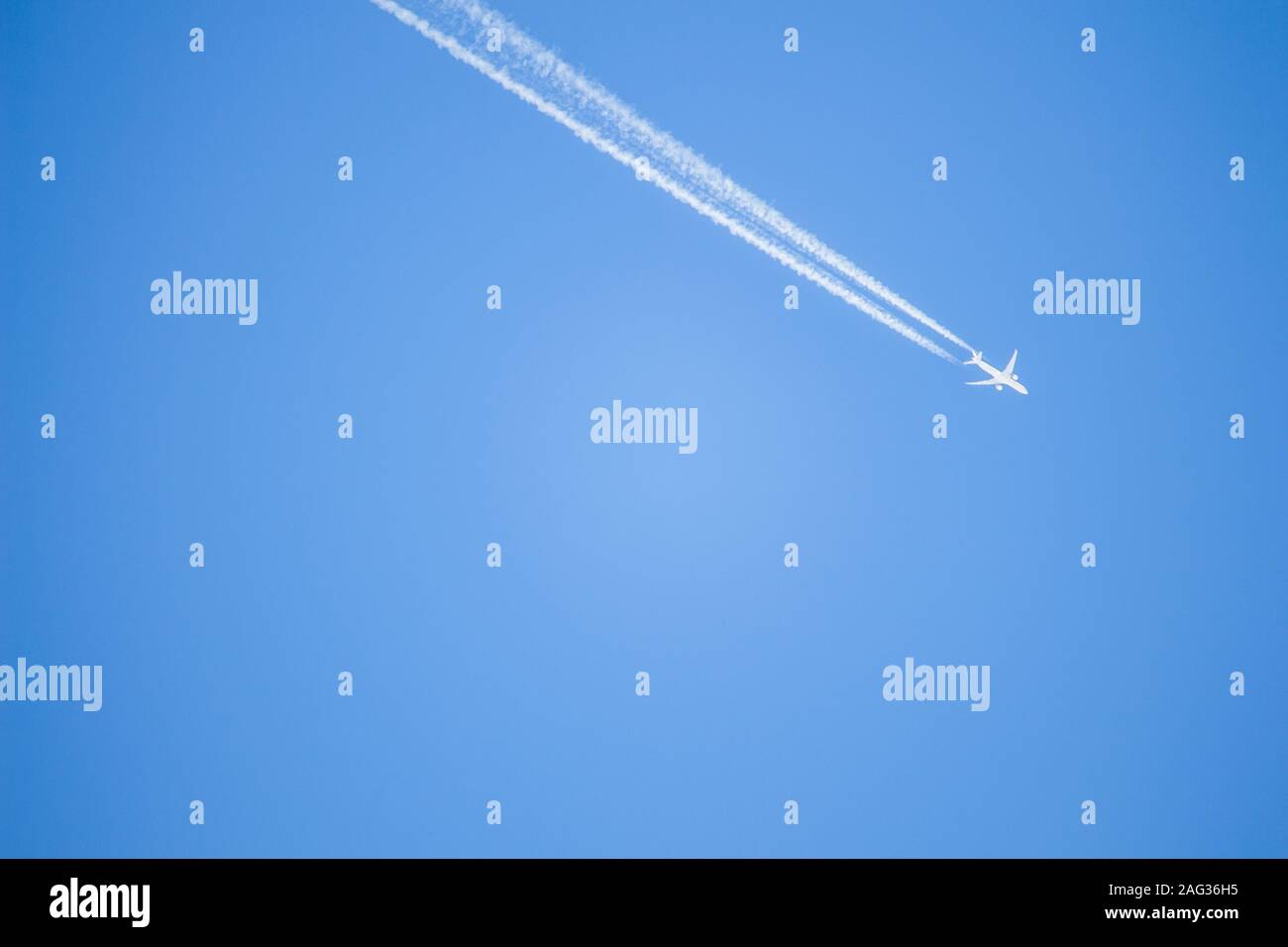 Beautiful shot of a white airplane flying and leaving its trail in the ...