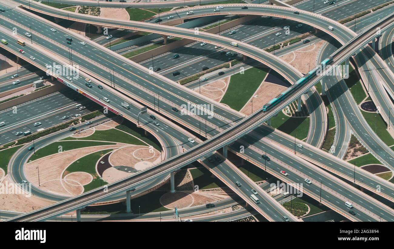 High angle shot of a big highway with multiple roads and a train riding ...