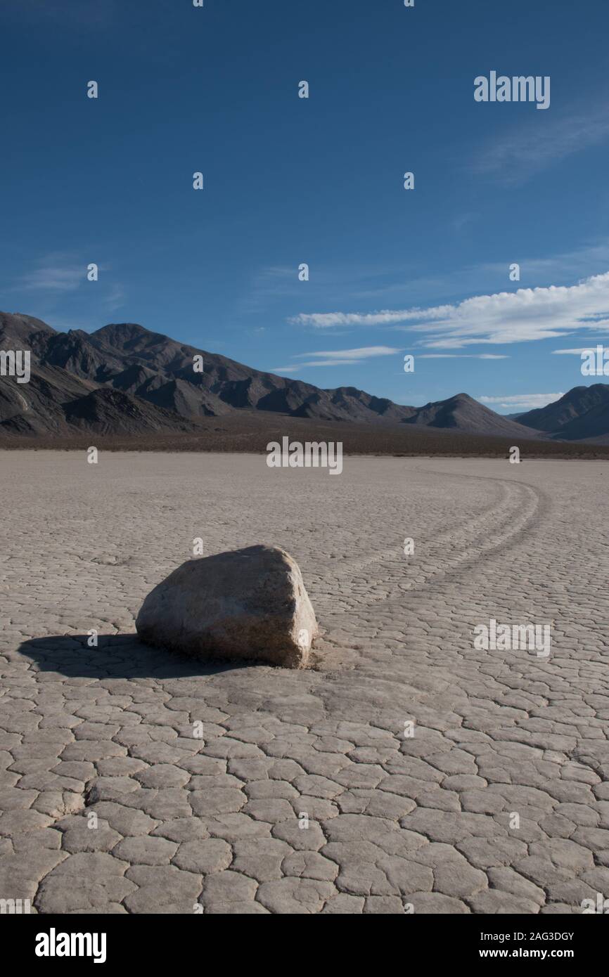 Vertical shot of a desert scene under the sky with one stone on the ...