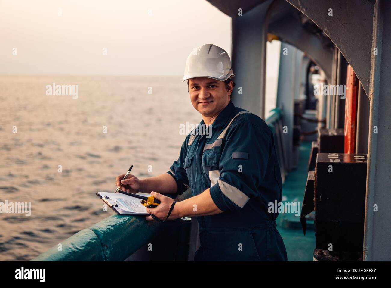 Deck Officer on deck of offshore vessel or ship , wearing PPE personal ...