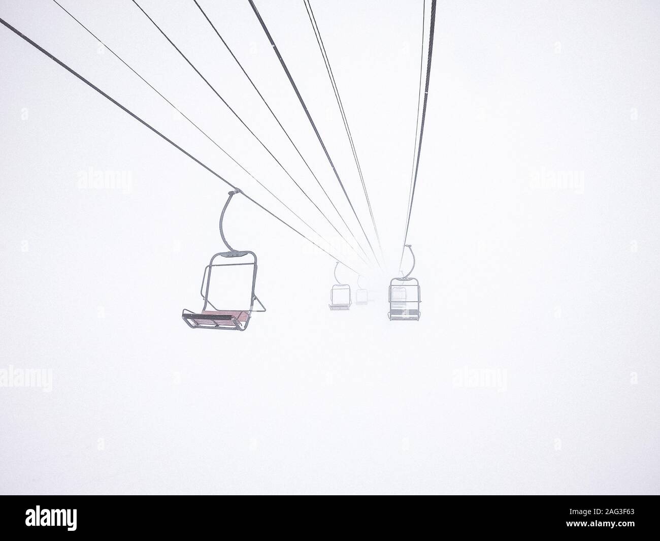 Horizontal shot of cable cars in the motion under the clear white sky ...