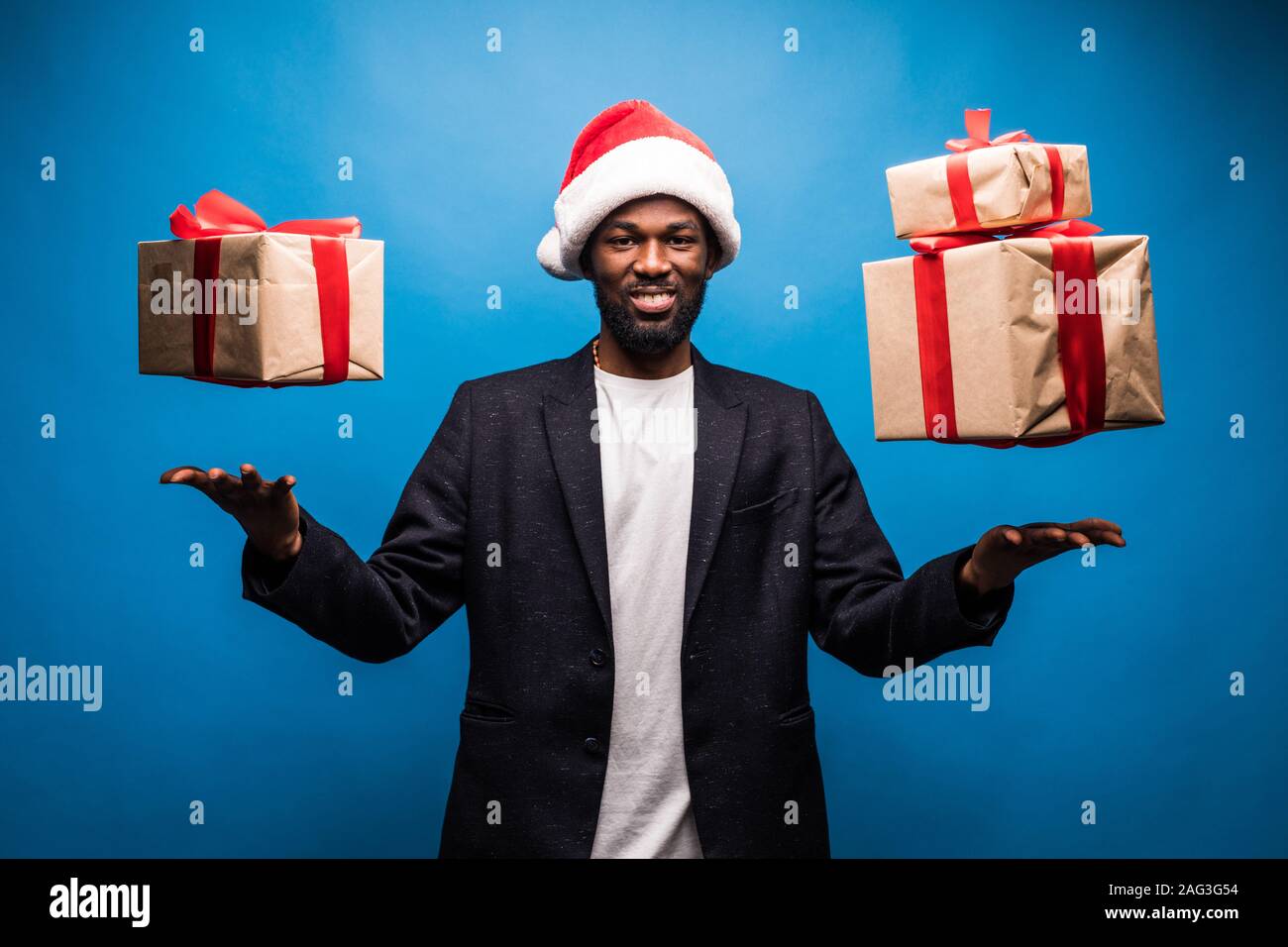 African American man in Santa hat throwing up gift box isolated Stock ...