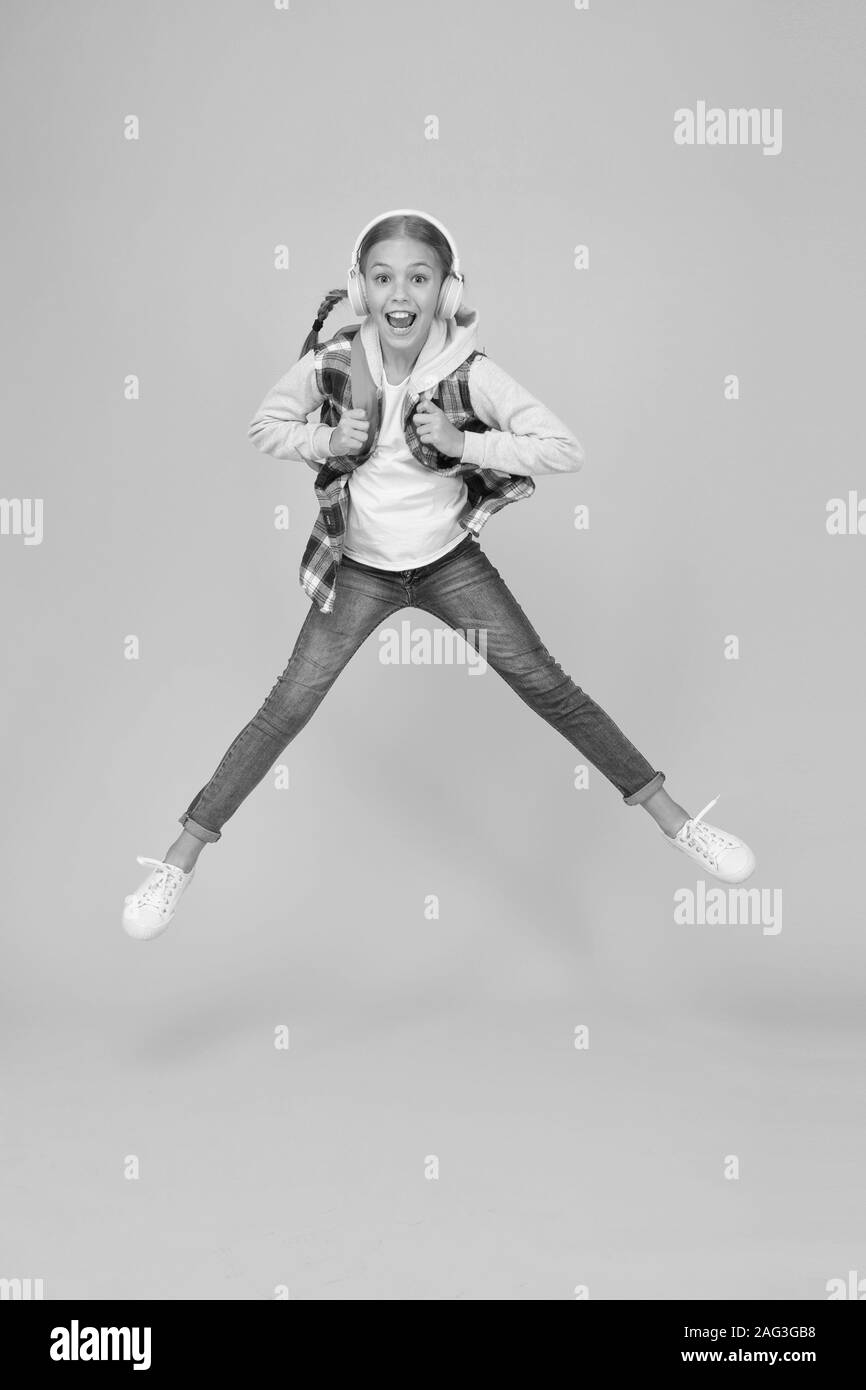 Energetic and enthusiastic. Energized small girl jump high with ...