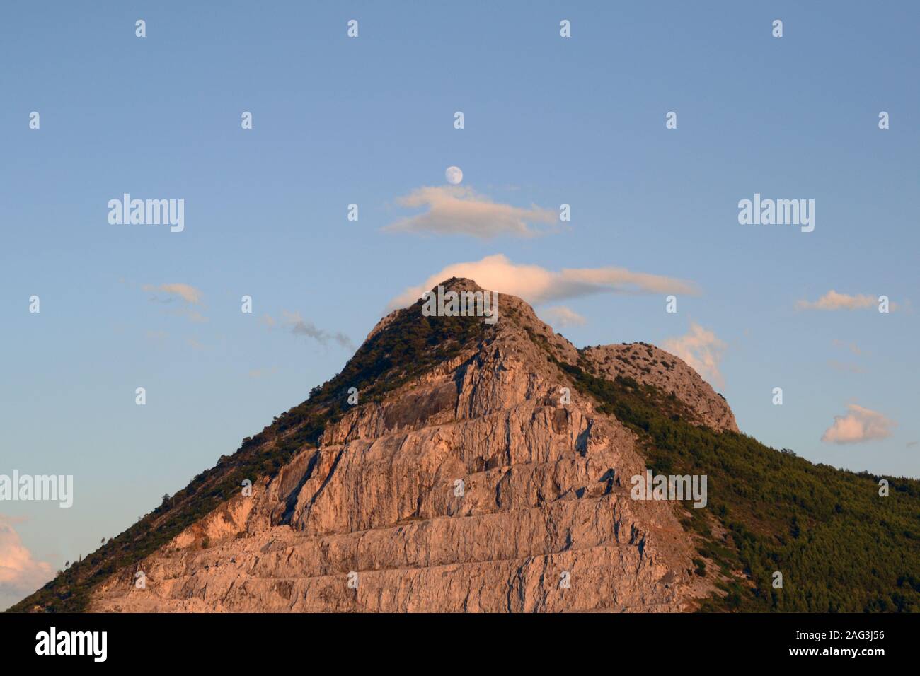 Low angle shot of the top of a hill under the bright sky and a small ...