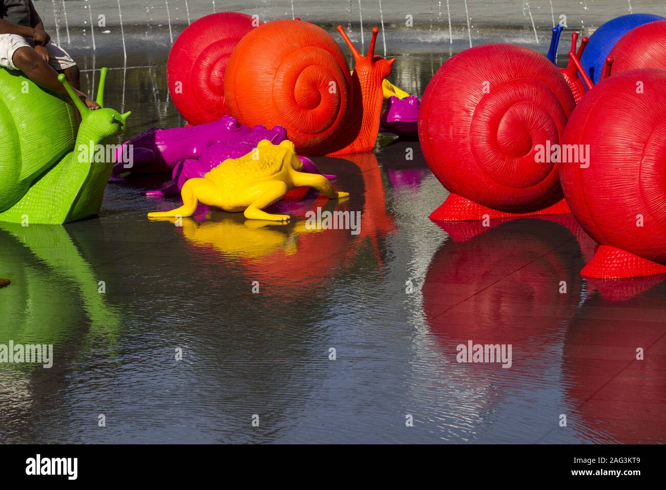 Artificial crowd of colorful sculptures of helixes and frogs hanging ...
