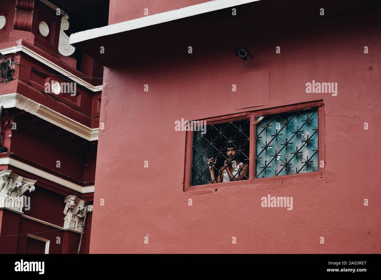 Men watching from the window of a red house Stock Photo - Alamy