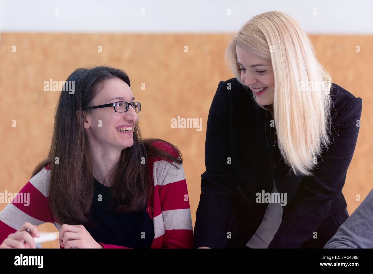 Beautiful young female teacher helping a student during class. Female ...