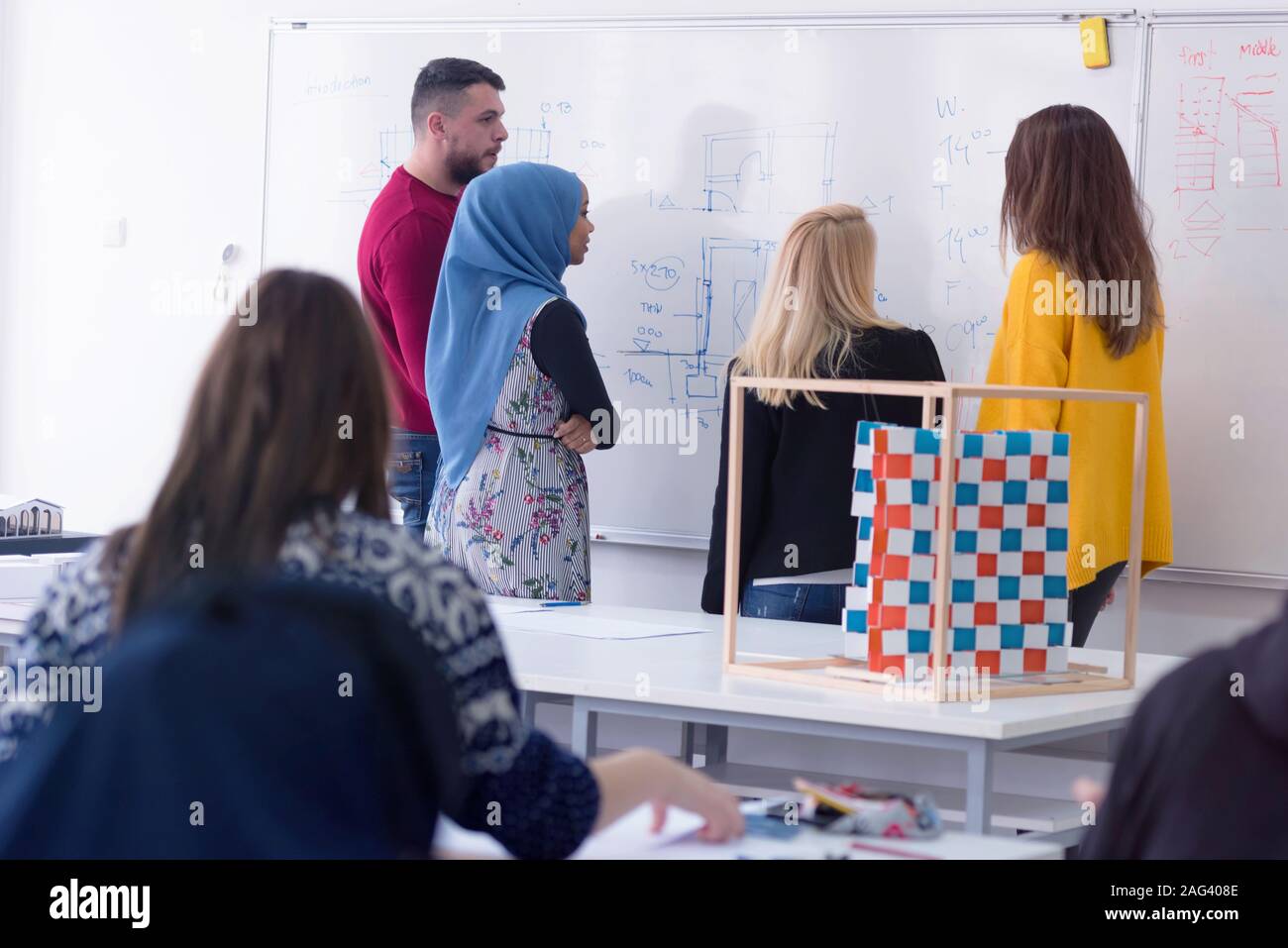 Beautiful young female teacher helping a student during class. Female ...