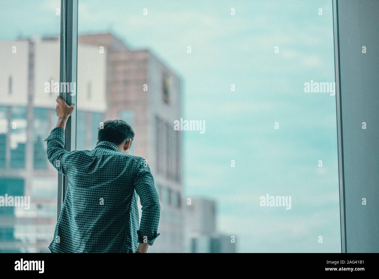 Person looking out a big window Stock Photo - Alamy
