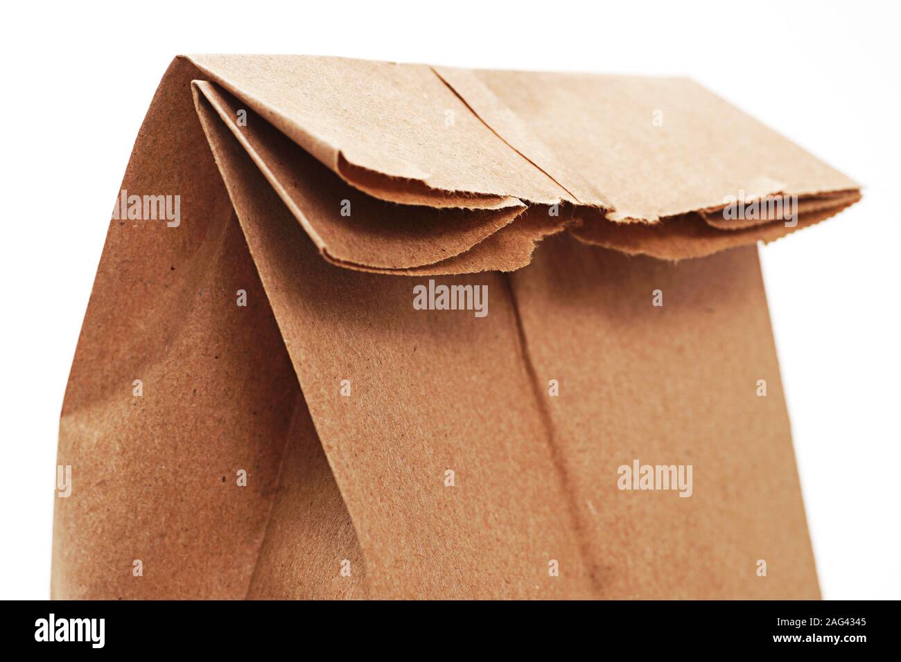 Blank paper bag folded closed at the top, isolated on white. Top of bag ...