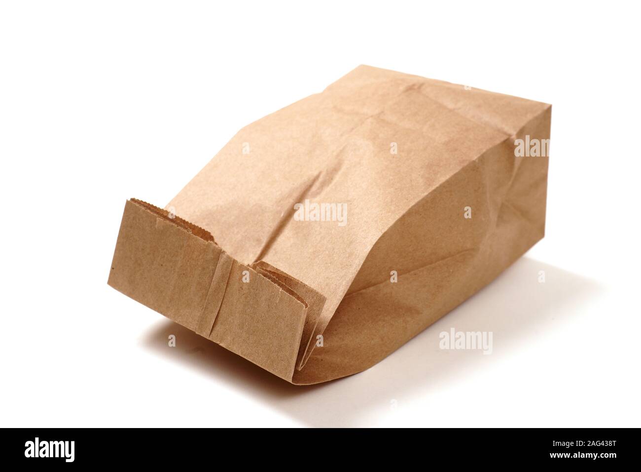 Blank paper bag folded closed at the top, isolated on white. Bag lying ...
