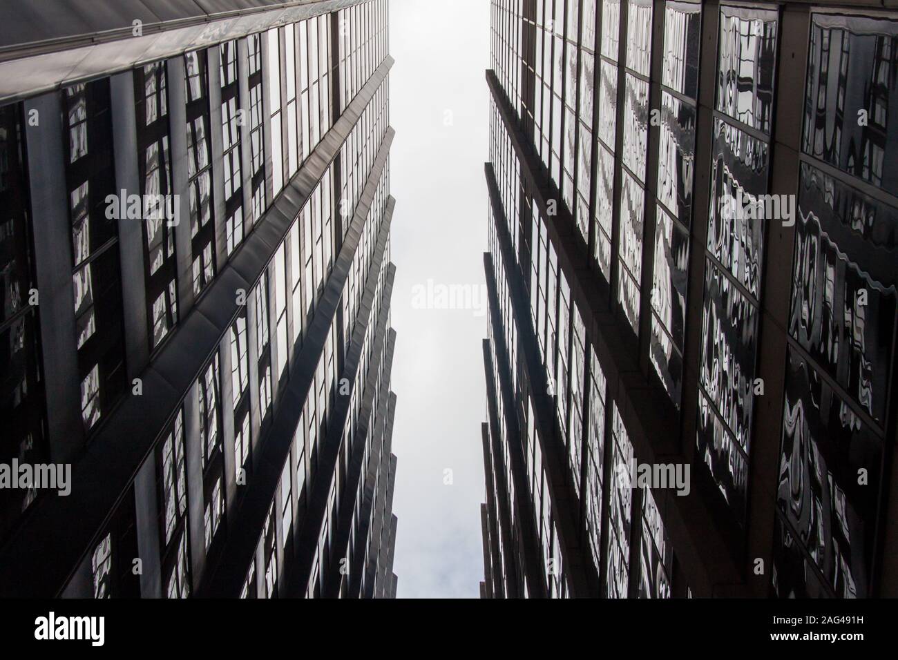 Low angle greyscale shot of two identical buildings and a line of the ...