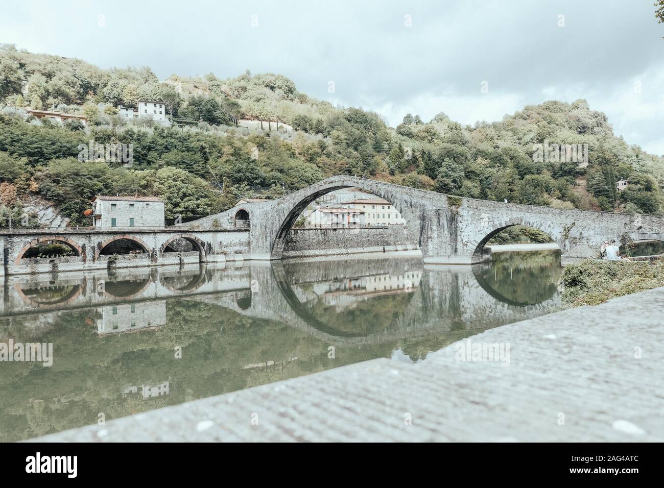 Beautiful scenery of a concrete arch bridge over the calm river ...