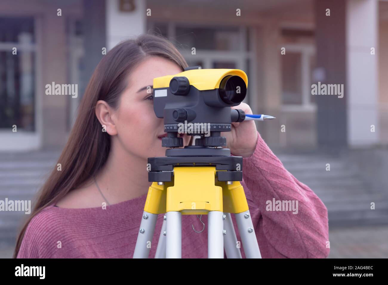 Young female engineer is measuring the distance on the road with the ...
