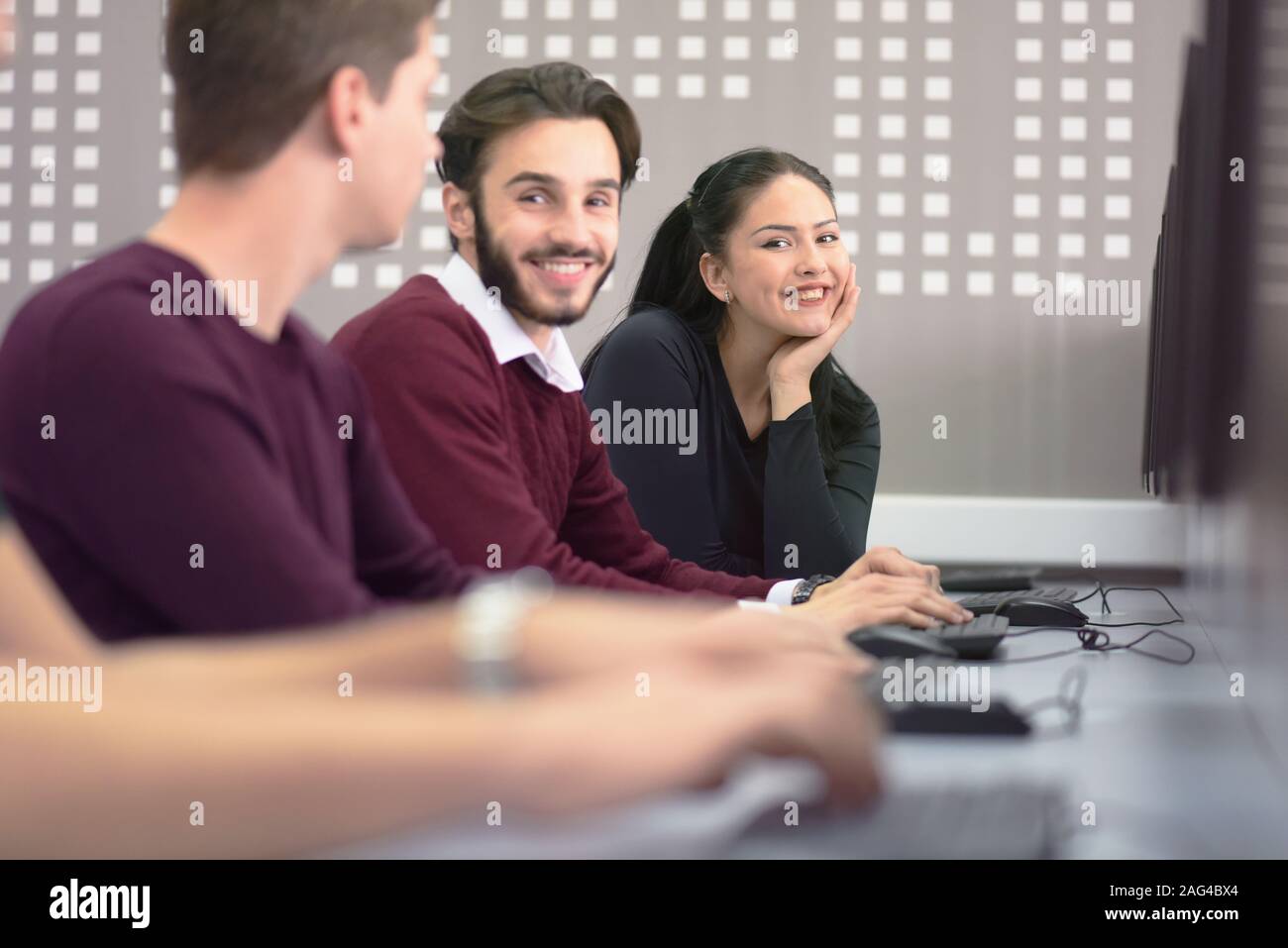 Side view of students using computer in lab. IT student looking and ...