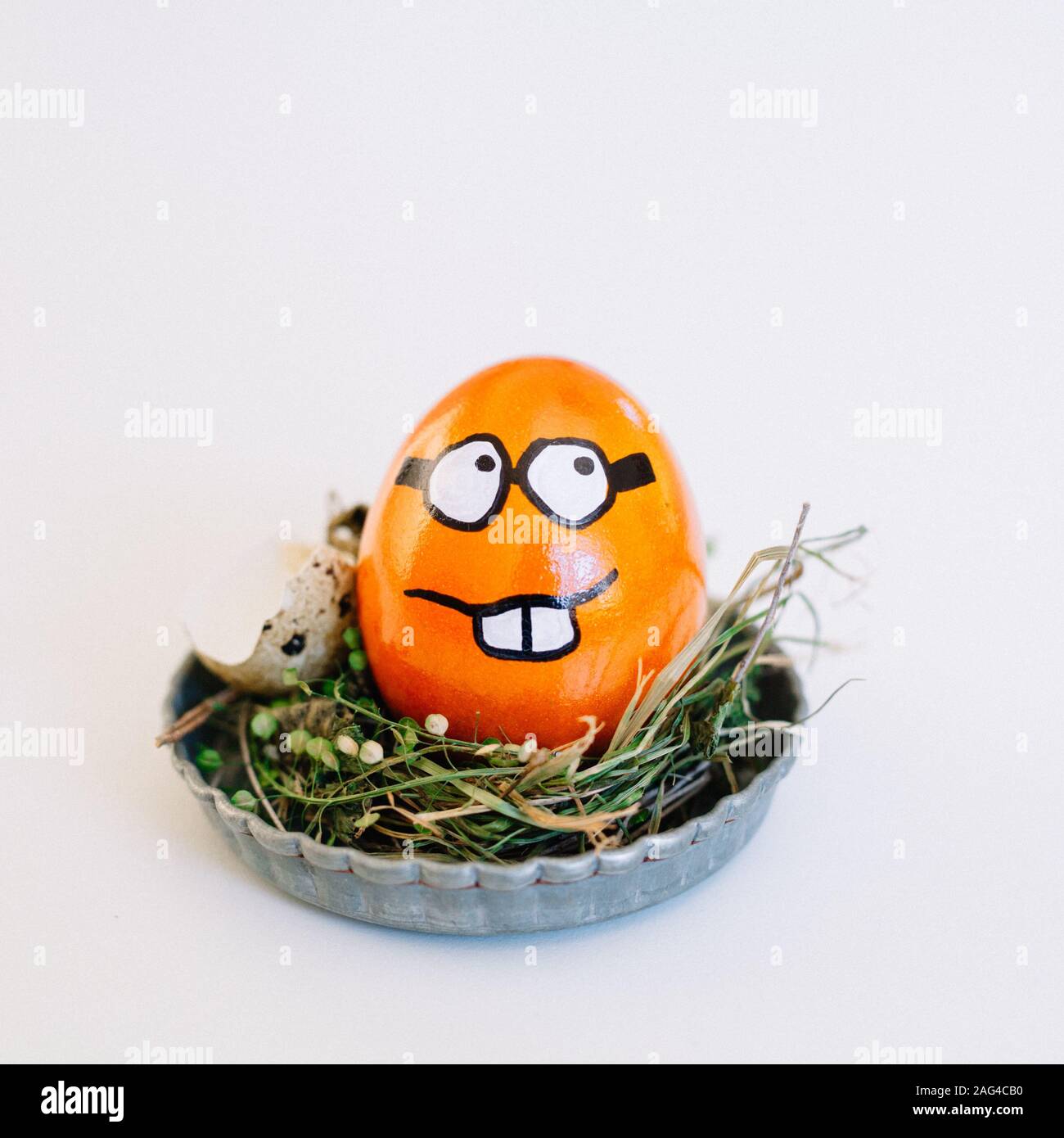 Depiction of a cute face with two teeth on an egg in a cute small plate ...