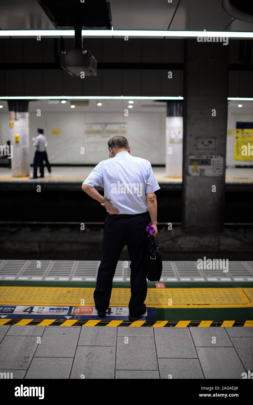 Man waits for subway, Tokyo, Japan Stock Photo - Alamy