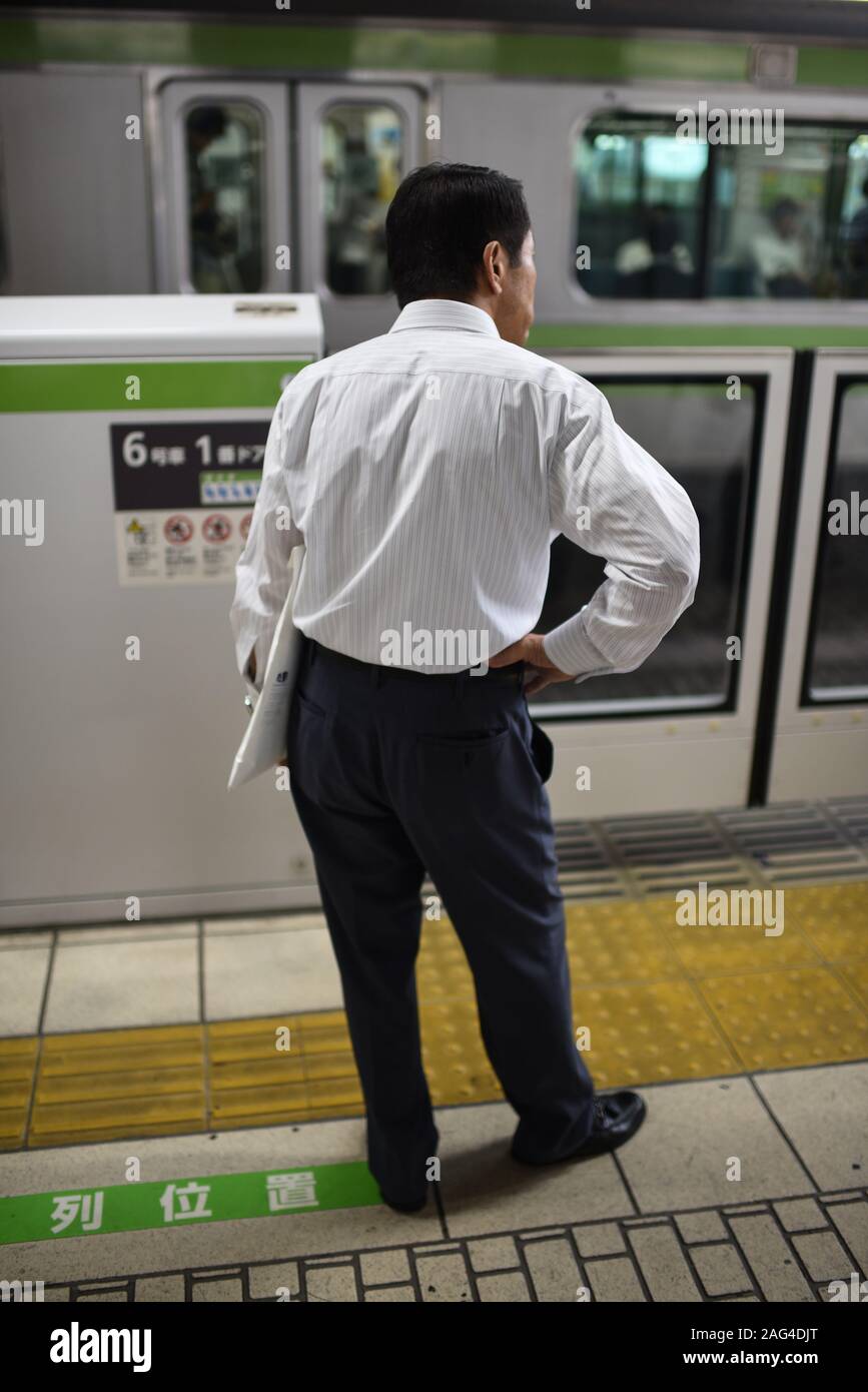Man waits for subway, Tokyo, Japan Stock Photo - Alamy