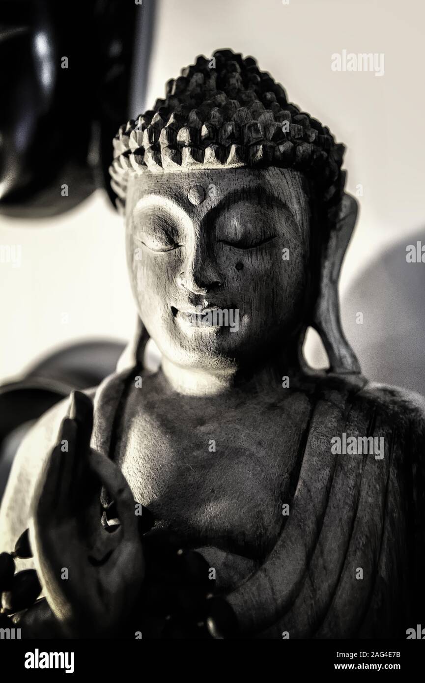Vertical closeup greyscale shot of Gautama Buddha statue isolated on a ...