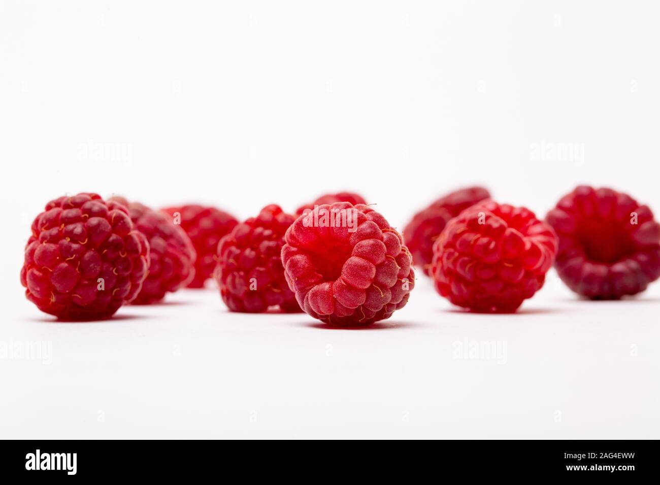 Closeup shot of fresh raspberries spread on a white background ...