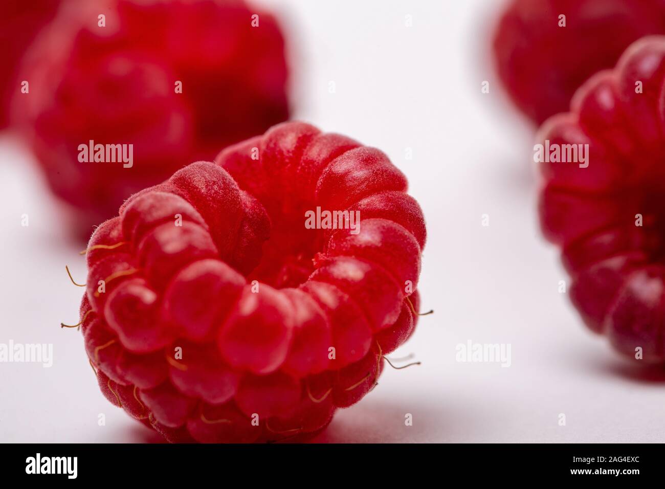 Closeup shot of fresh raspberries spread on a white background ...