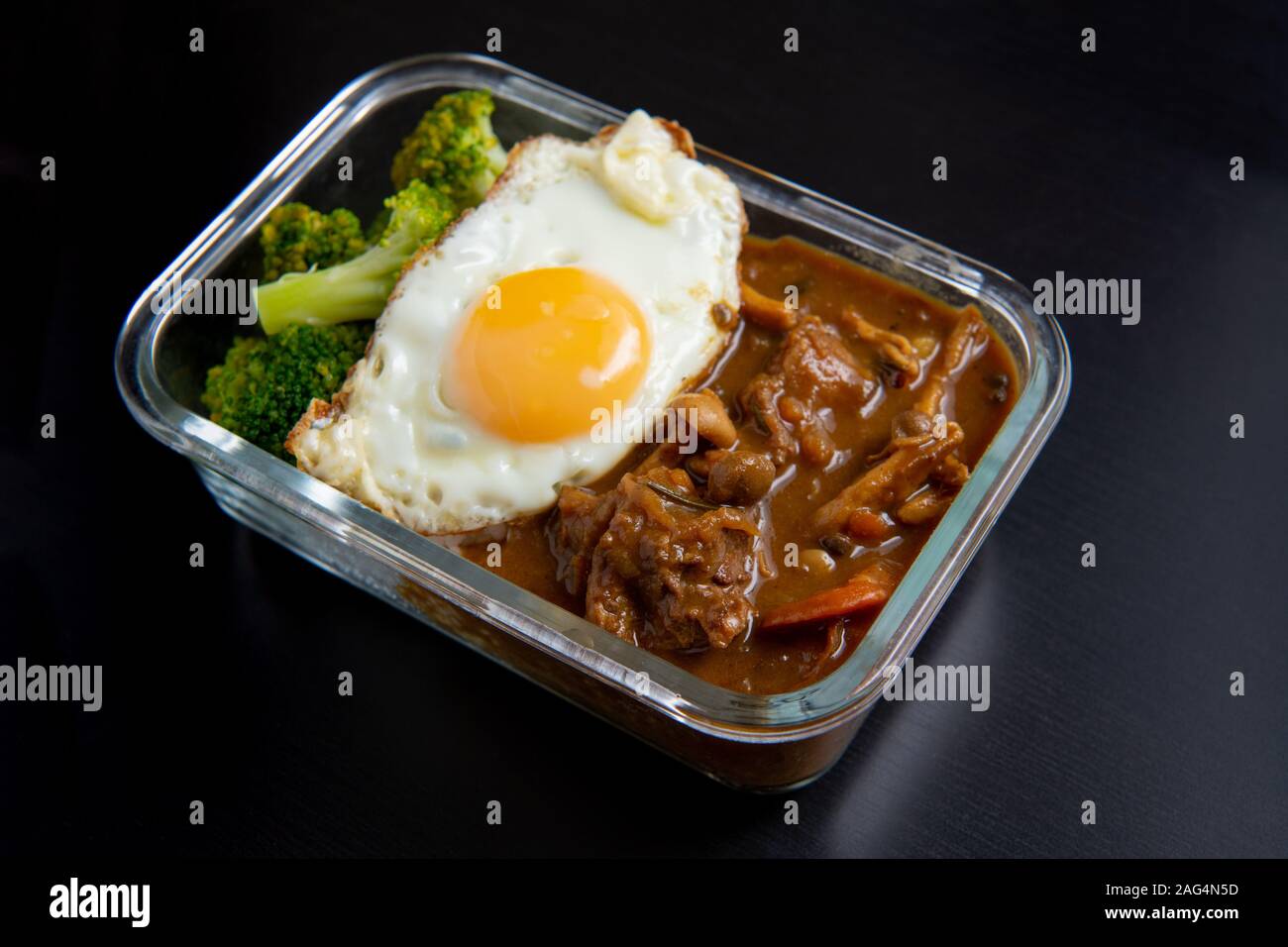 Beef curry rice in glass lunch box on black wooden dining table ( Onsen ...