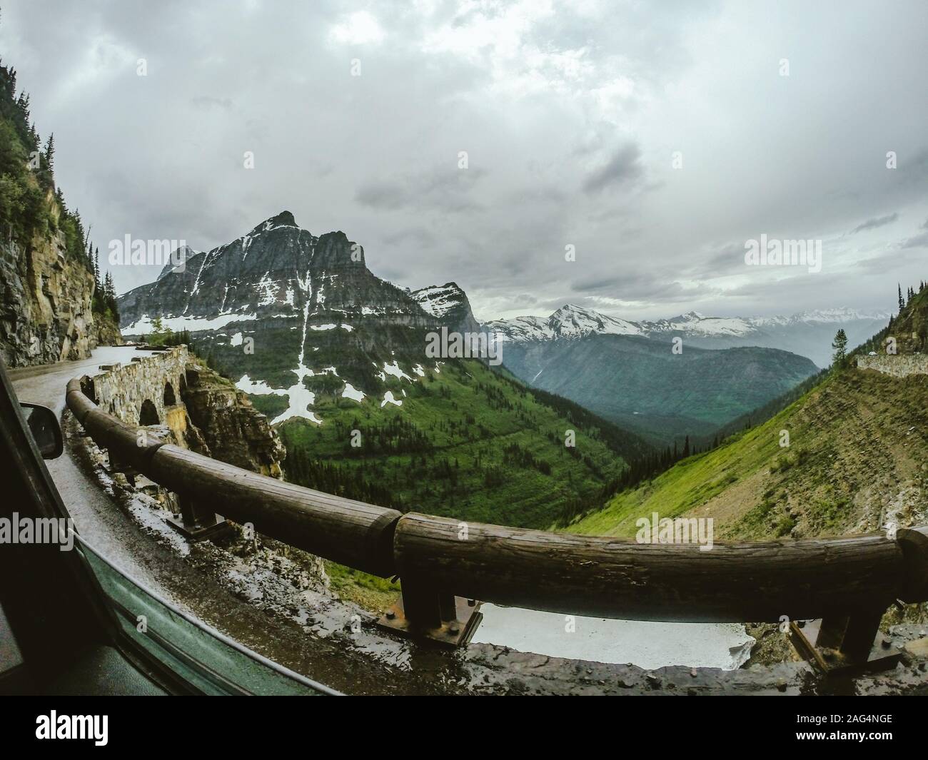 Going-to-the-sun Road near green mountains covered with snow in Glacier ...