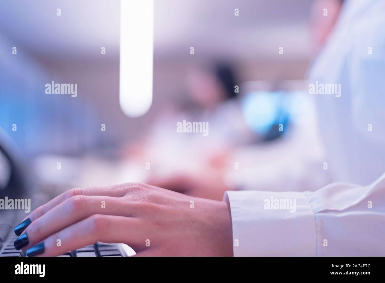 Female security guard working on computers while sitting in the main ...