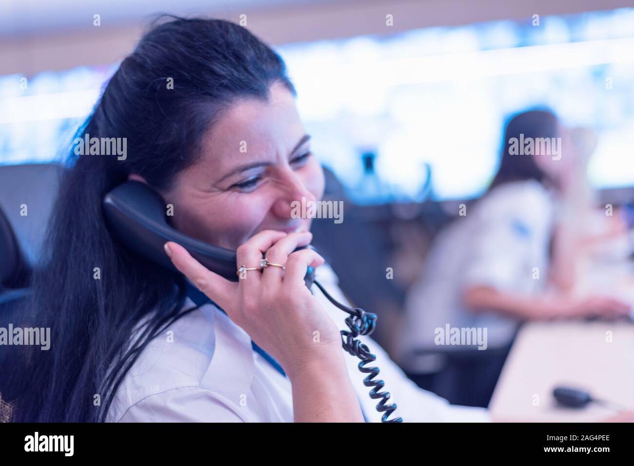Female security guard operator talking on the phone, calling in the ...