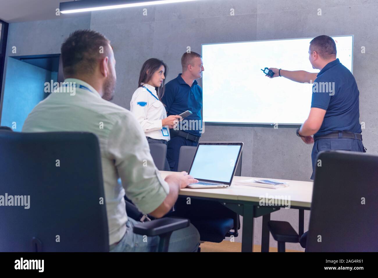 Group of security guards working on computers while sitting in the main ...